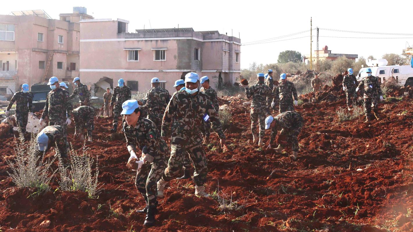 Nepalese peacekeepers assist Blida residents to prepare field for olive ...
